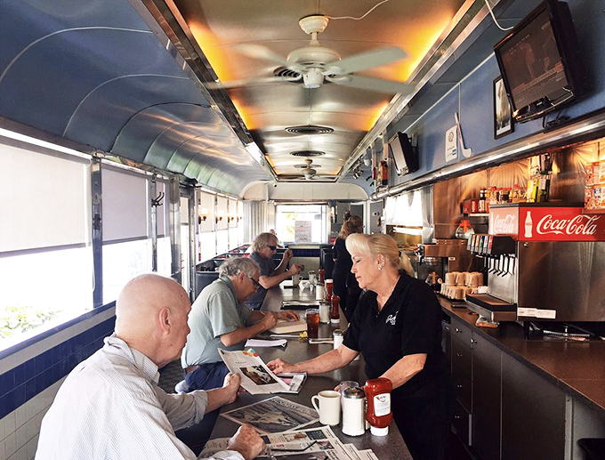 The counter—where solo diners find company, newspapers get thoroughly read, and regulars exchange gossip with servers who remember their orders.