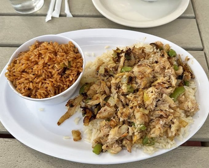Red rice alongside a mountain of crab meat and vegetables—a plate that tells the story of Gullah-Geechee culinary influence in every grain.