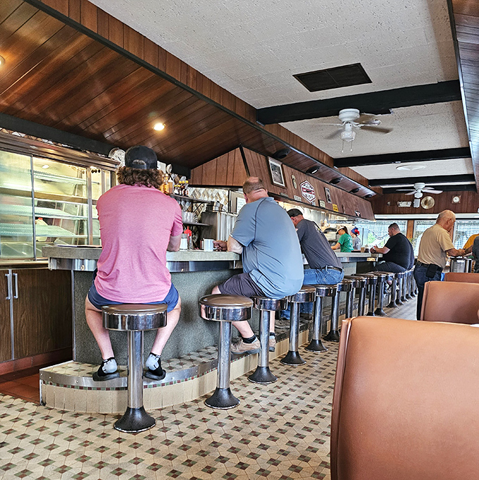 The counter crew—a morning ritual where strangers become neighbors over coffee refills and shared newspaper sections.