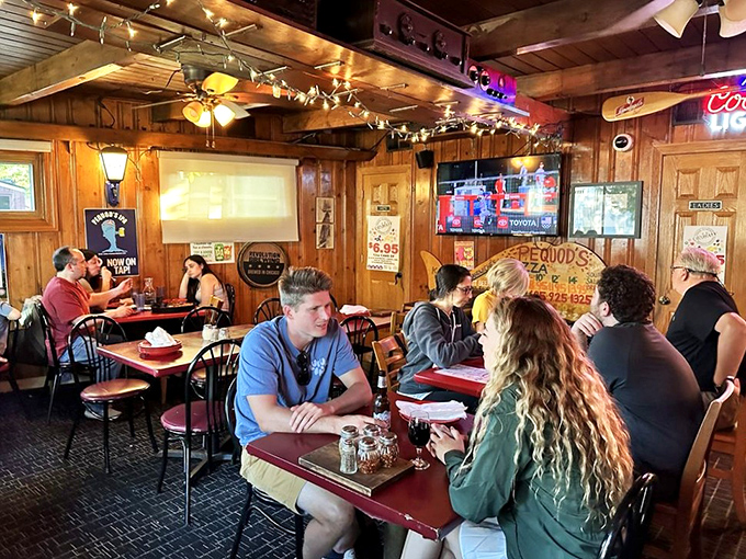 A dining room filled with people experiencing pizza euphoria. Notice nobody's looking at their phones – the pie demands full attention.