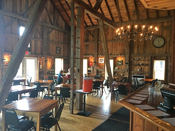 Exposed beams, natural light, and simple wooden tables create a dining space that says "farmhouse chic" without shouting it.