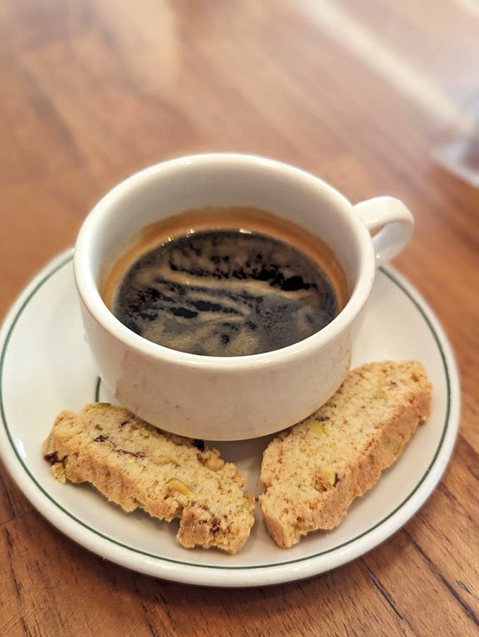 Coffee and biscotti—civilization's perfect pairing. The espresso's rich crema promises the caffeine embrace needed to face the day ahead.