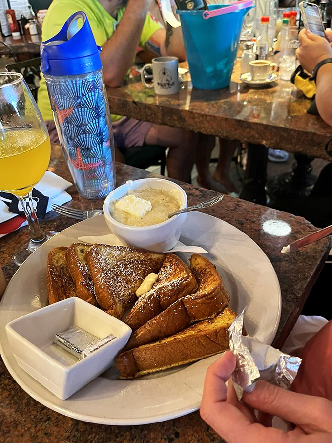 French toast transformed into an art form—thick-cut, golden brown, and served with a side of grits that would make any Southerner nod in approval.