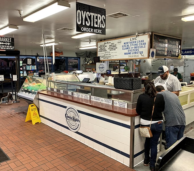 The seafood counter—where decisions are made, relationships tested, and the day's catch waits patiently for its moment of culinary glory.