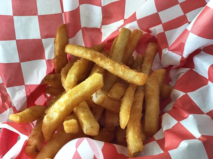 Golden fries served in a checkered basket—the universal language of satisfaction. Crispy on the outside, fluffy inside, and impossible to stop eating.