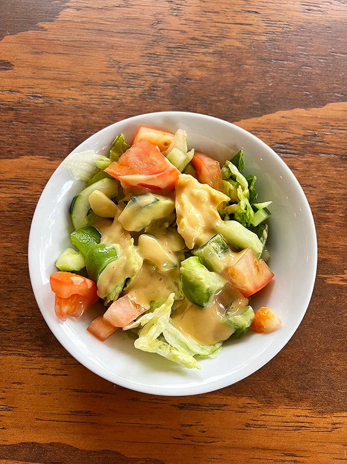 This house salad proves Germans understand vegetables too—crisp, fresh, and swimming just enough dressing to make cucumber and tomato feel special.