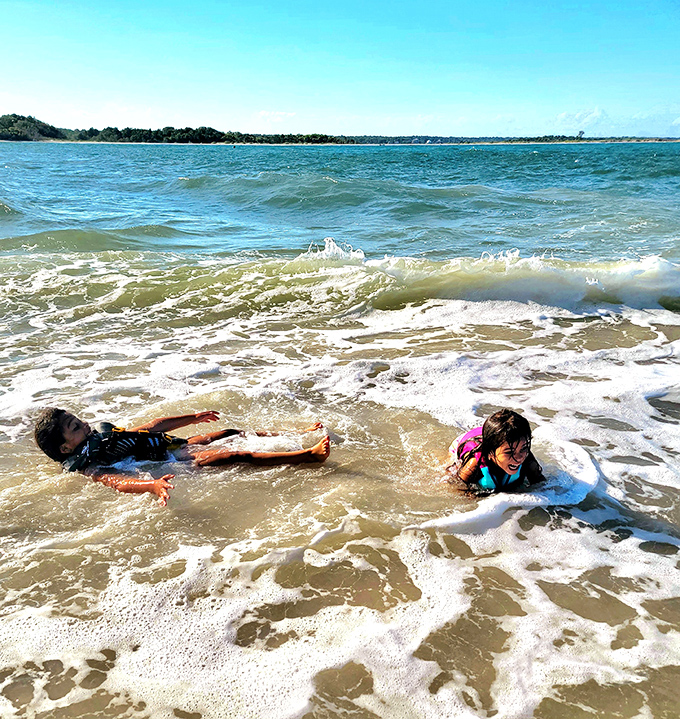 Kids discovering the universal truth that ocean waves make better playgrounds than any expensive theme park ever could.