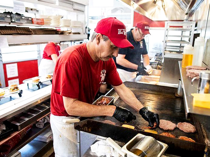The grill masters at work—where burger flipping isn't just a job, it's performance art with delicious consequences. 