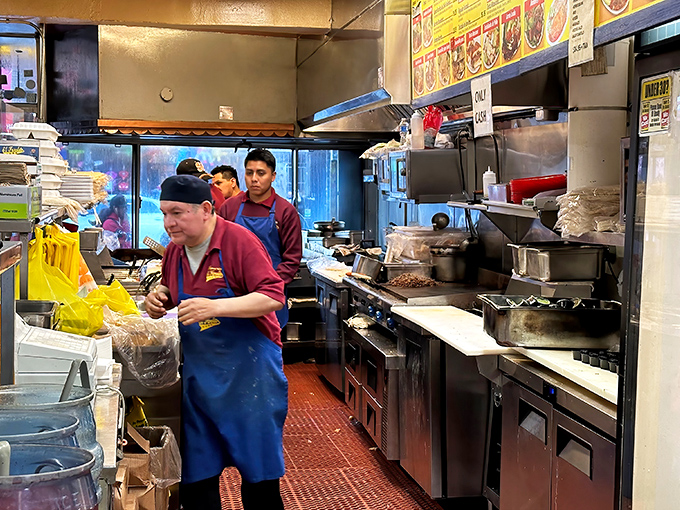 The kitchen ballet—where skilled hands have wrapped more burritos than most of us have had hot meals, all with mesmerizing efficiency.