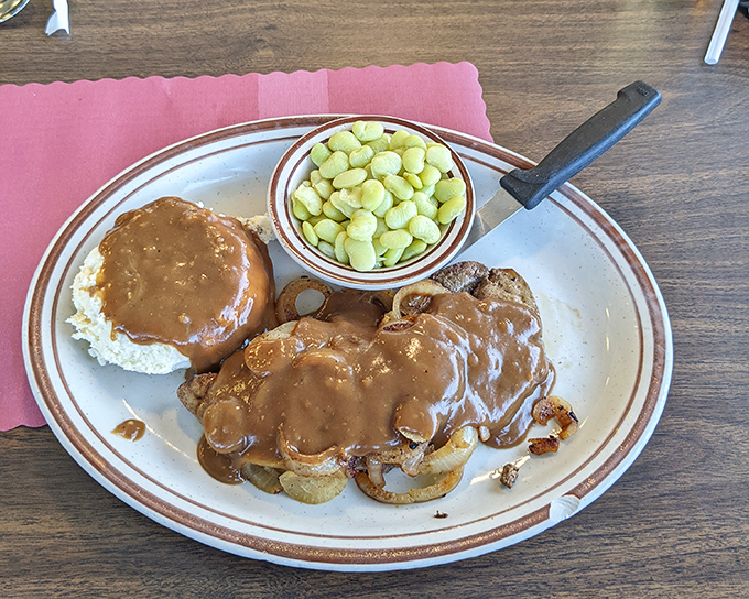 Country cooking that tells a story—tender liver smothered in gravy with a side of lima beans. This plate screams "I learned to cook from someone who knew what they were doing."