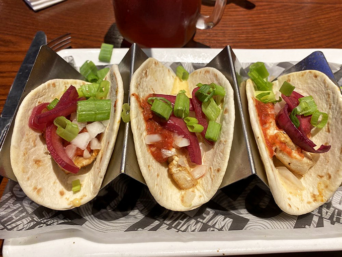 Tacos served in metal holders—civilization's answer to the age-old question: "How do I keep these delicious fillings from escaping?"