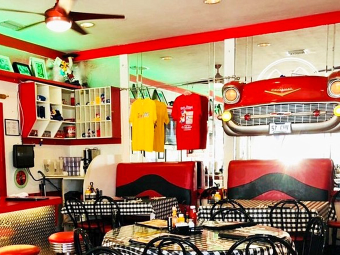 The front-end of a classic Chevy serves as décor while t-shirts hang like trophies—American nostalgia you can eat with your eyes.