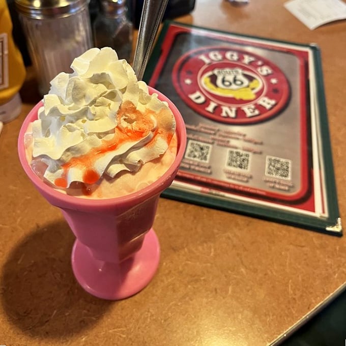 This milkshake isn't just thick—it's contemplating a run for political office. Served in a classic pink glass with whipped cream that defies gravity.
