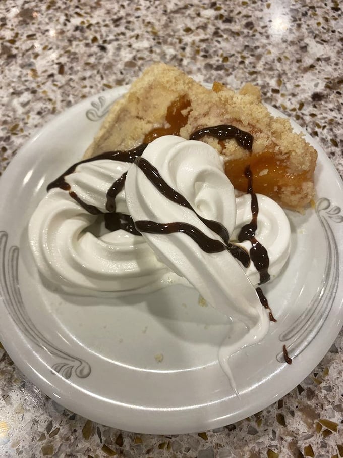 Not just pie – a cloud of whipped cream atop warm fruit filling that makes you understand why "pie in the sky" is the ultimate reward.