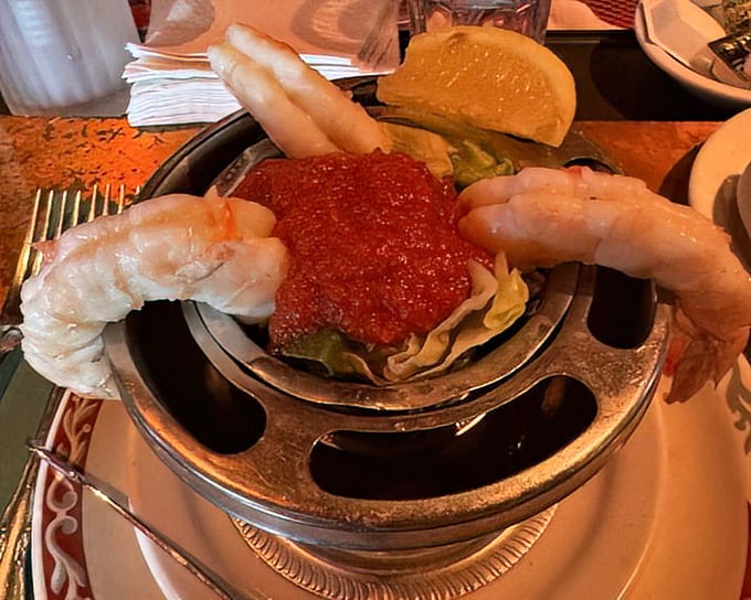 The shrimp cocktail – those curved crustaceans standing at attention around their saucy center like delicious sentinels guarding flavor itself.