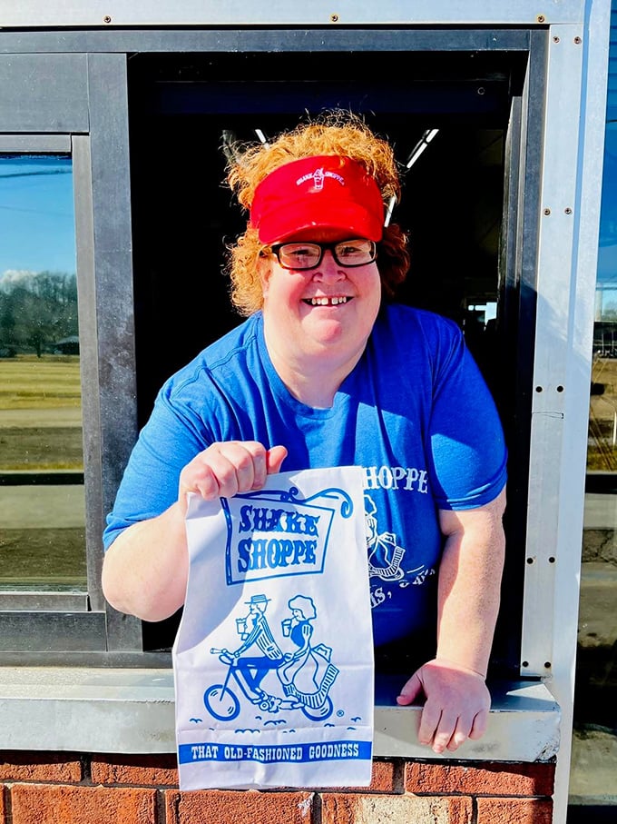 The drive-thru window reveals a friendly face and that iconic white bag—proof that good things come in simple packages.
