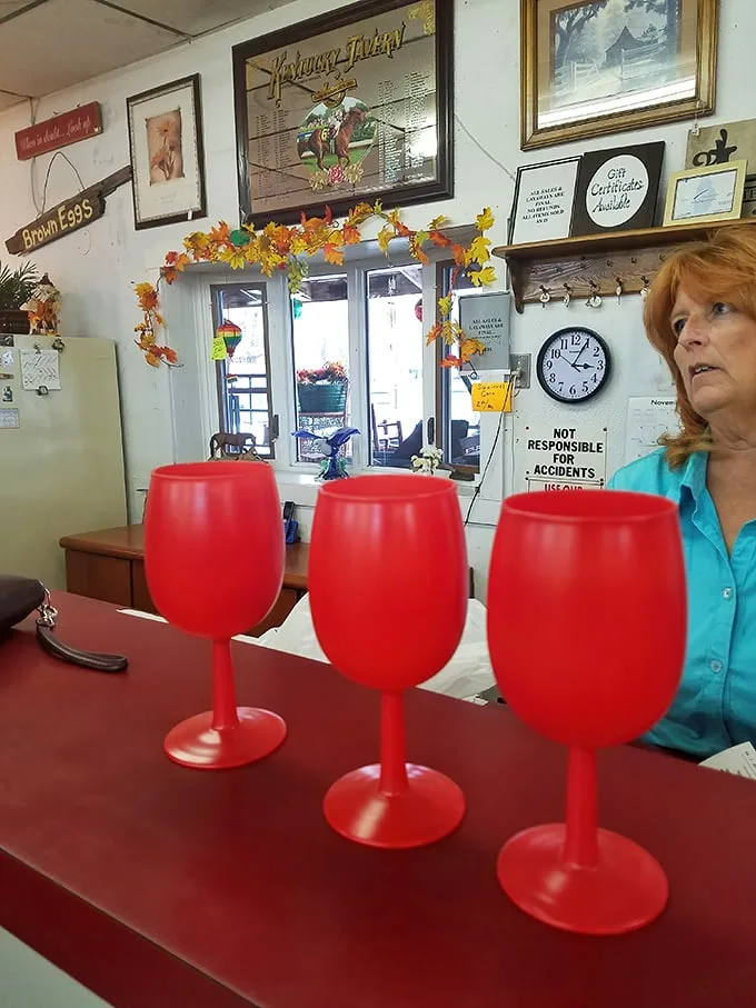 Red wine glasses await new homes while the shop keeps watch. Every item here passes through caring hands before finding yours.