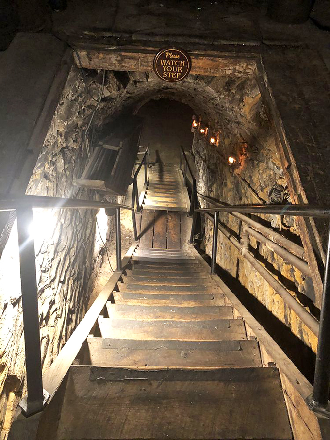 "Watch your step" indeed—these wooden stairs descend into the legendary Catacombs, where dining adventures happen 43 feet below the streets of Mount Joy.