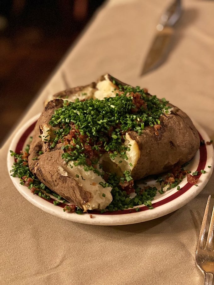 The loaded baked potato comes adorned with a garden of chives and bacon – a side dish substantial enough to be a meal elsewhere.