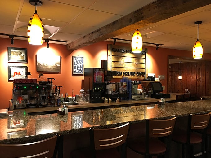The bar area glows with amber pendant lights, creating an inviting hub. This isn't a place for complicated mixology—it's where honest drinks complement honest food.