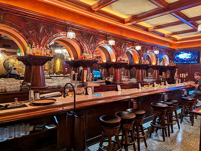 This isn't just a bar – it's a cathedral to cocktail craftsmanship, where the arched woodwork frames bottles like precious artifacts in a museum of merriment.
