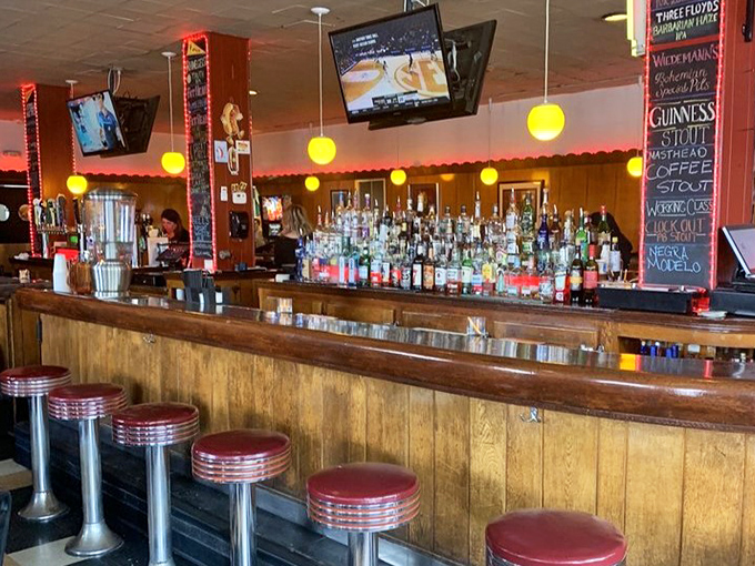 The bar gleams with promise, classic red stools inviting you to perch and ponder life's important questions—like whether to try the Guinness or local craft IPA.
