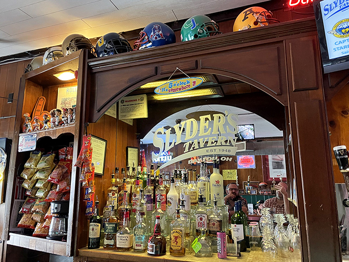 The bar at Slyder's isn't just serving drinks; it's preserving a slice of Americana behind that beautifully worn wooden arch.
