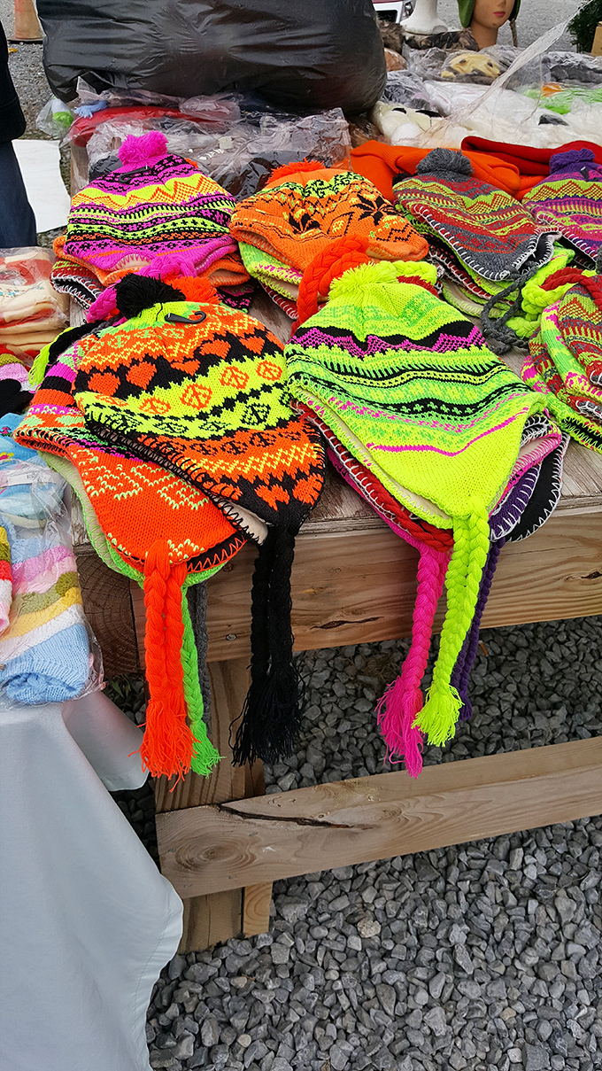Neon knit hats explode with color against the wooden table. These aren't just winter warmers—they're wearable art with personality to spare.