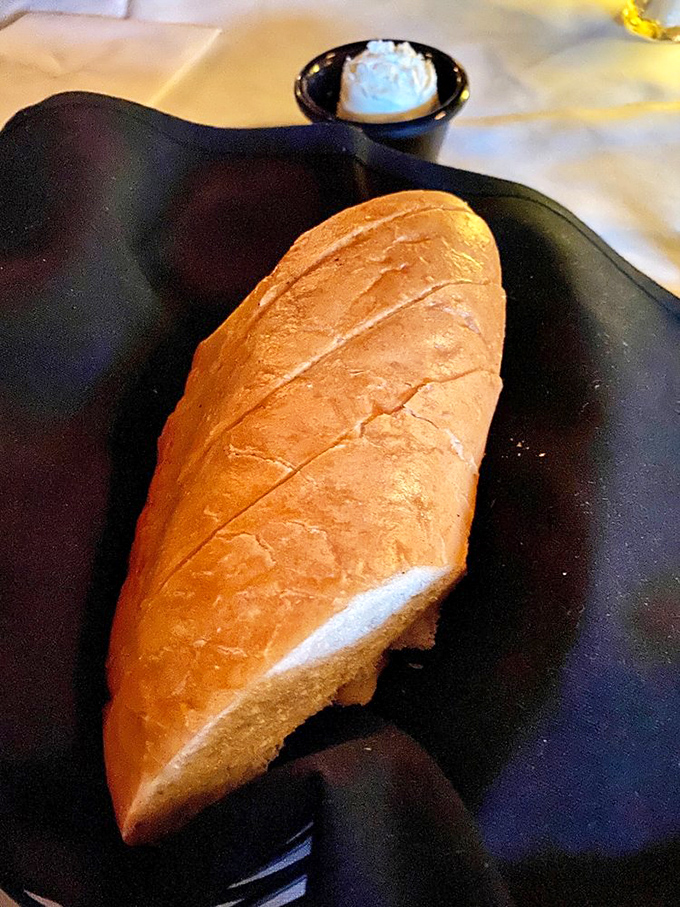 Fresh bread that arrives warm and ready for its supporting role—though it often steals the scene before the main course arrives.