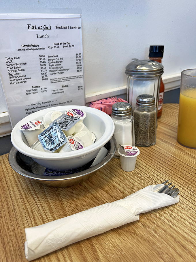 The table setting—a still life painting titled "Anticipation," featuring the supporting cast of salt, pepper, and sweetener packets.