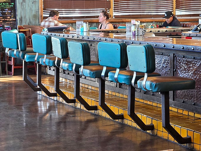 Counter seating where solo diners become temporary neighbors and the blue chairs invite you to stay for just one more coffee.