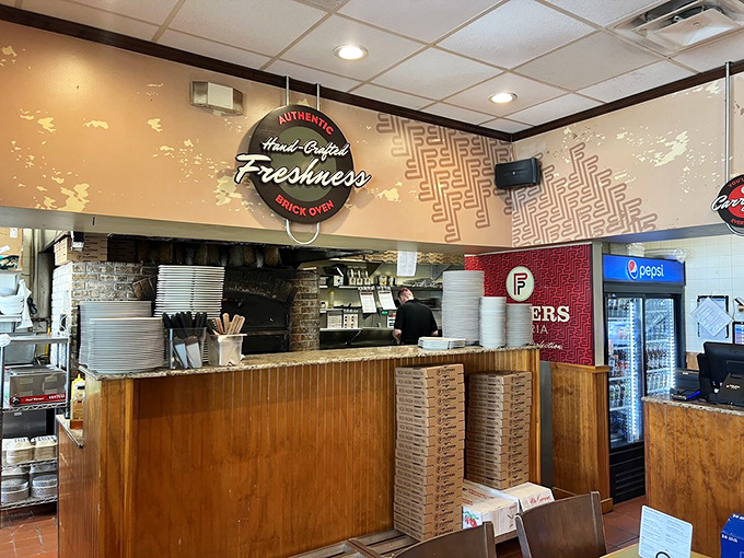 Behind this counter, pizza artisans work their magic. The "Hand-Crafted Freshness" sign isn't just decoration—it's a promise.