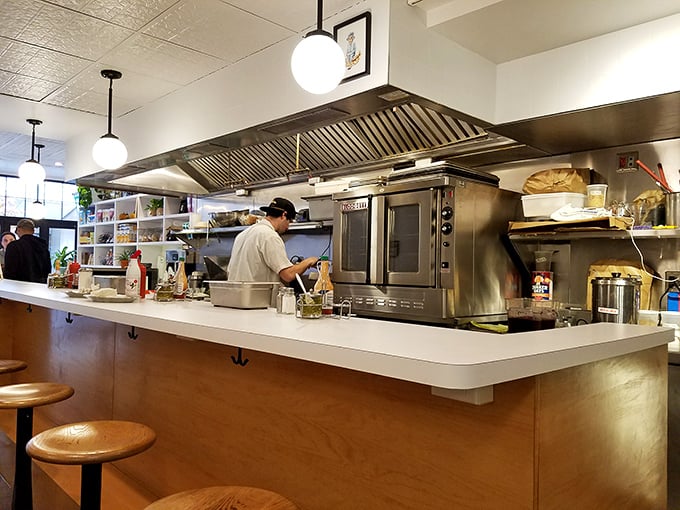 The open kitchen design isn't just practical—it's dinner theater where sandwiches are the stars and every flip of the spatula deserves applause.