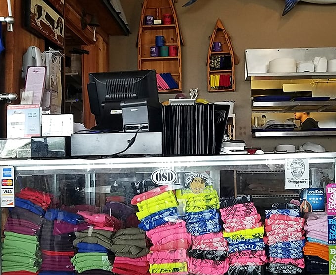 Colorful t-shirts stacked like a rainbow behind the counter—because the best souvenirs are the ones that make friends back home jealous.