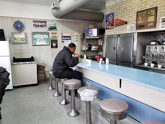 A lone diner enjoying his meal at the counter – participating in a Detroit tradition as authentic as a Motown record.