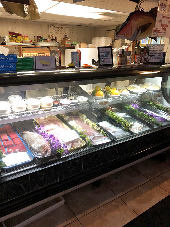 The display case showcases today's fresh catches, adorned with edible flowers. This isn't just seafood—it's seafood that dressed up for the occasion.