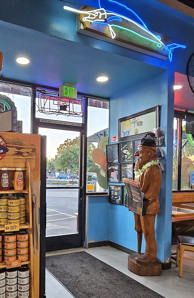 That wooden fisherman statue isn't just decoration—he's the silent guardian of seafood excellence. The blue walls and neon fish create a maritime wonderland.