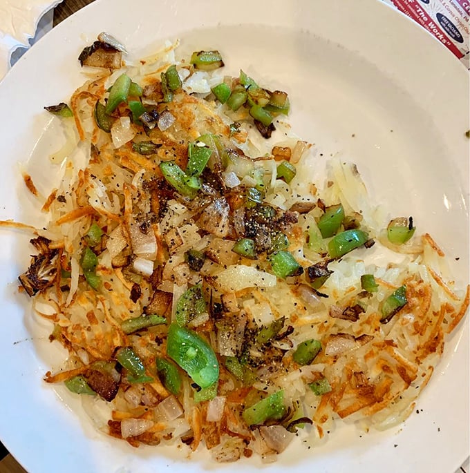 These home fries, speckled with caramelized onions and peppers, aren't just a side dish – they're the unsung heroes of the breakfast plate.