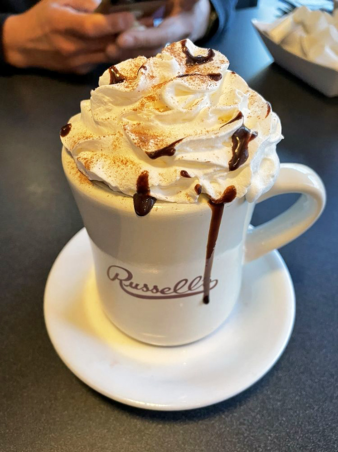 This isn't just hot chocolate—it's a mountain of whipped cream with chocolate rivers cascading down its slopes.
