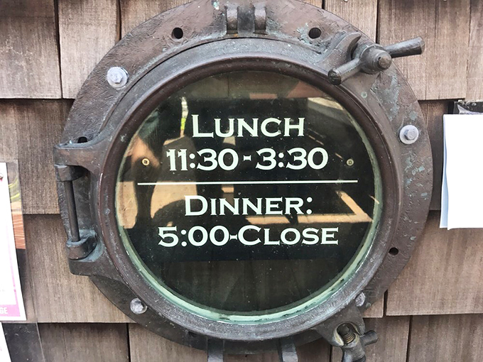 Hours displayed in a ship's porthole—the perfect maritime touch for a restaurant that clearly knows its identity. Functional whimsy at its finest.