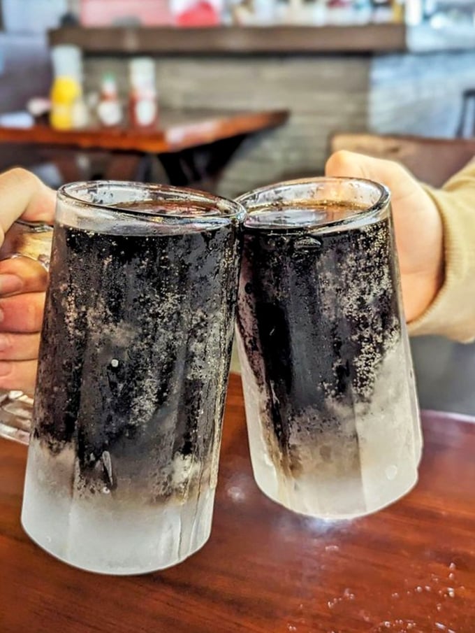 Frosty mugs of dark goodness—because nothing cuts through smoky fish flavors like an ice-cold root beer or cola.