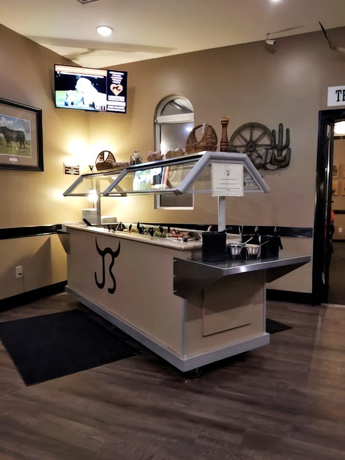 The salad bar station stands ready for action, emblazoned with the restaurant's logo like a culinary coat of arms.