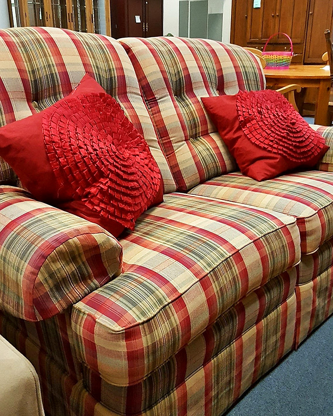 This plaid loveseat with decorative pillows isn't just sitting there – it's auditioning for the role of "favorite napping spot" in your living room.