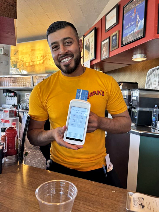 The smile says it all—genuine hospitality never goes out of style. This is service with actual joy, not the corporate-mandated kind.
