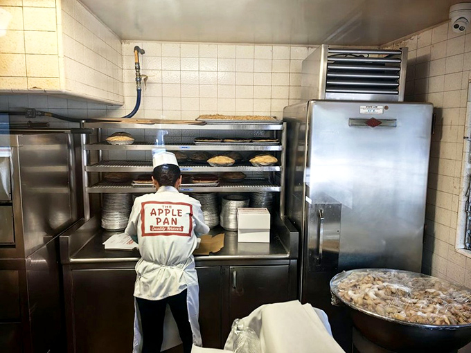 Behind the scenes where pie magic happens. Those white uniforms aren't retro fashion statements – they're working clothes for serious culinary business.