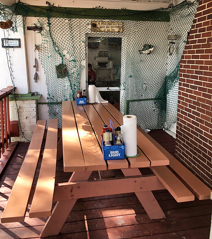 This picnic table, draped in fishing net, isn't just seating—it's your personal battlefield for the delicious crab confrontation that awaits.