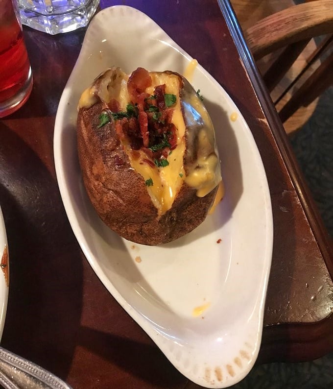 Not just any baked potato—this loaded beauty is a meal unto itself. Melted cheese cascades down the sides while bacon and herbs stand ready to elevate each bite.