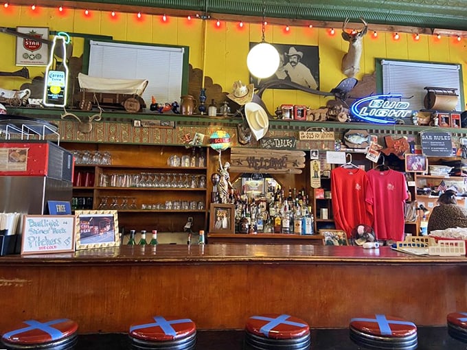The bar stretches like a timeline of Texas drinking history – neon signs glowing with promises of cold beer and good times.