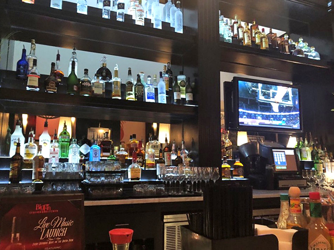 The Trophy Bar's impressive spirits collection stands at attention. A liquid library where every bottle tells a story waiting to be poured.