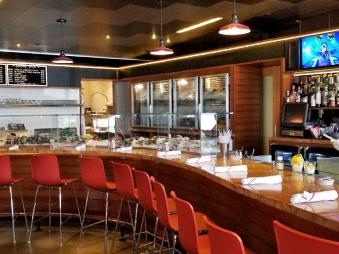 The bar area—where oyster dreams come true and cocktails are crafted with the same precision as the seafood they accompany.